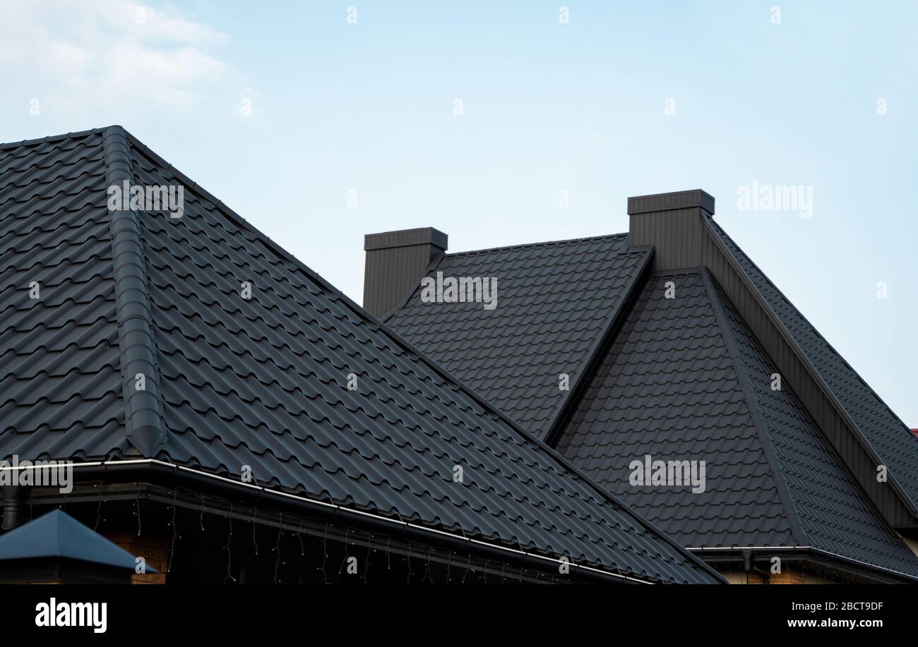 Black metal tile roof. Roof metal sheets. Modern types of roofing ...