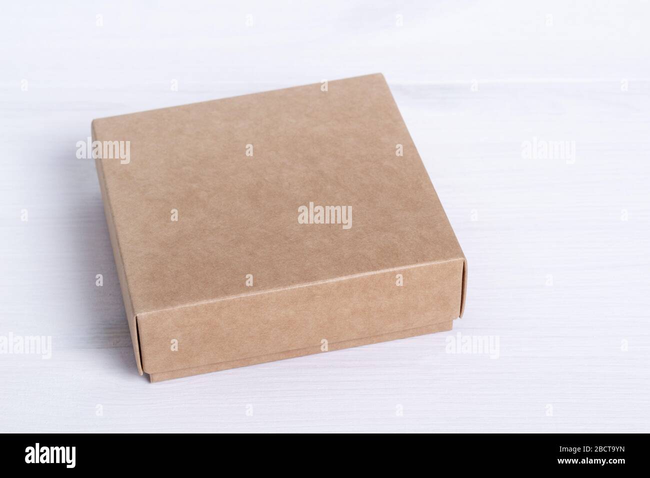 Blank cardboard box package isolated on white wood background. Craft ...