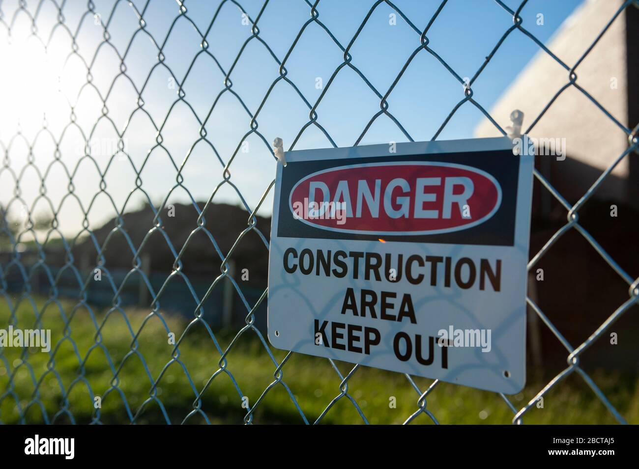 Danger sign on chain link fence surrounding construction site Stock ...