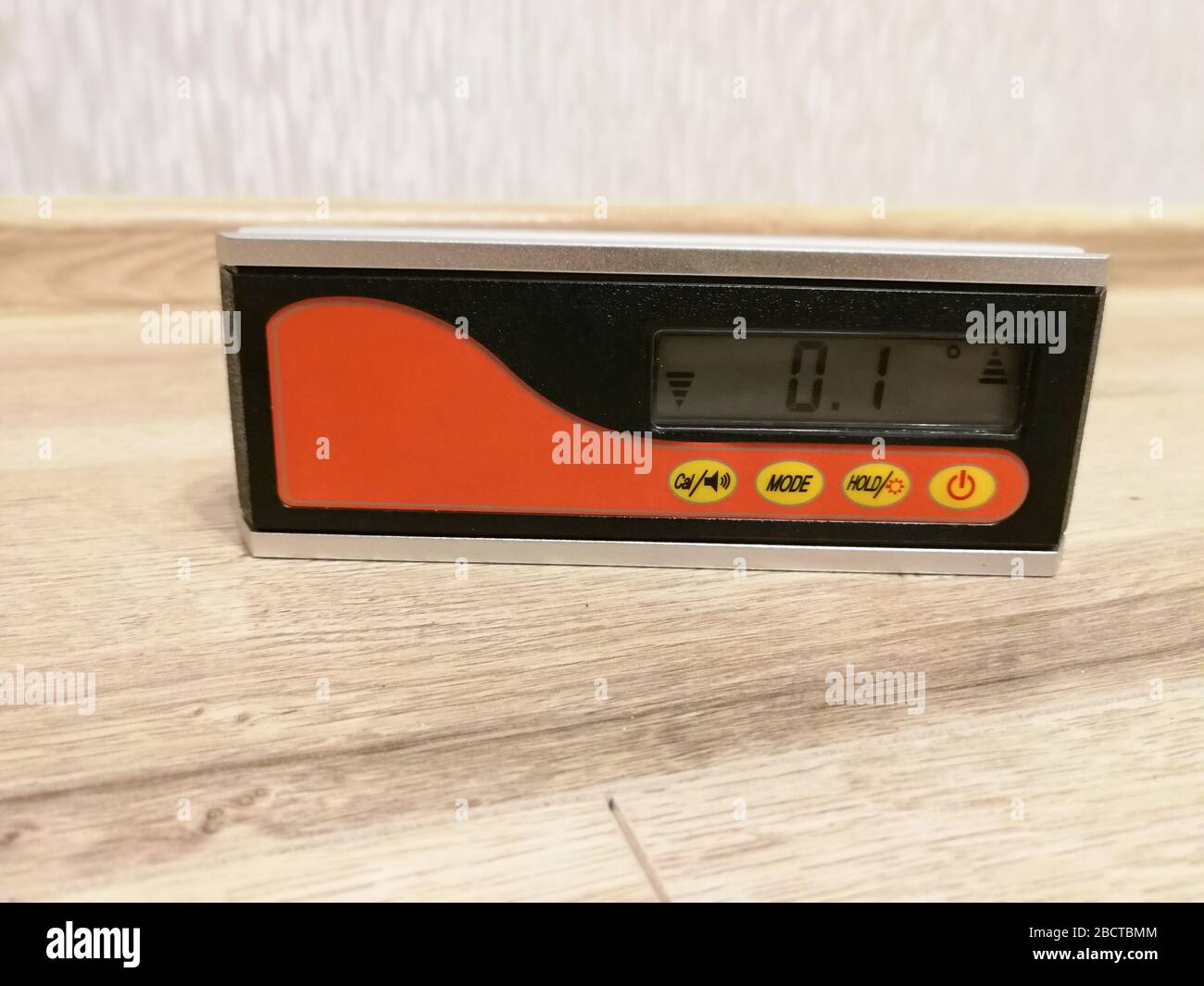 Professional digital tool inclinometer on the wooden floor for leveling ...
