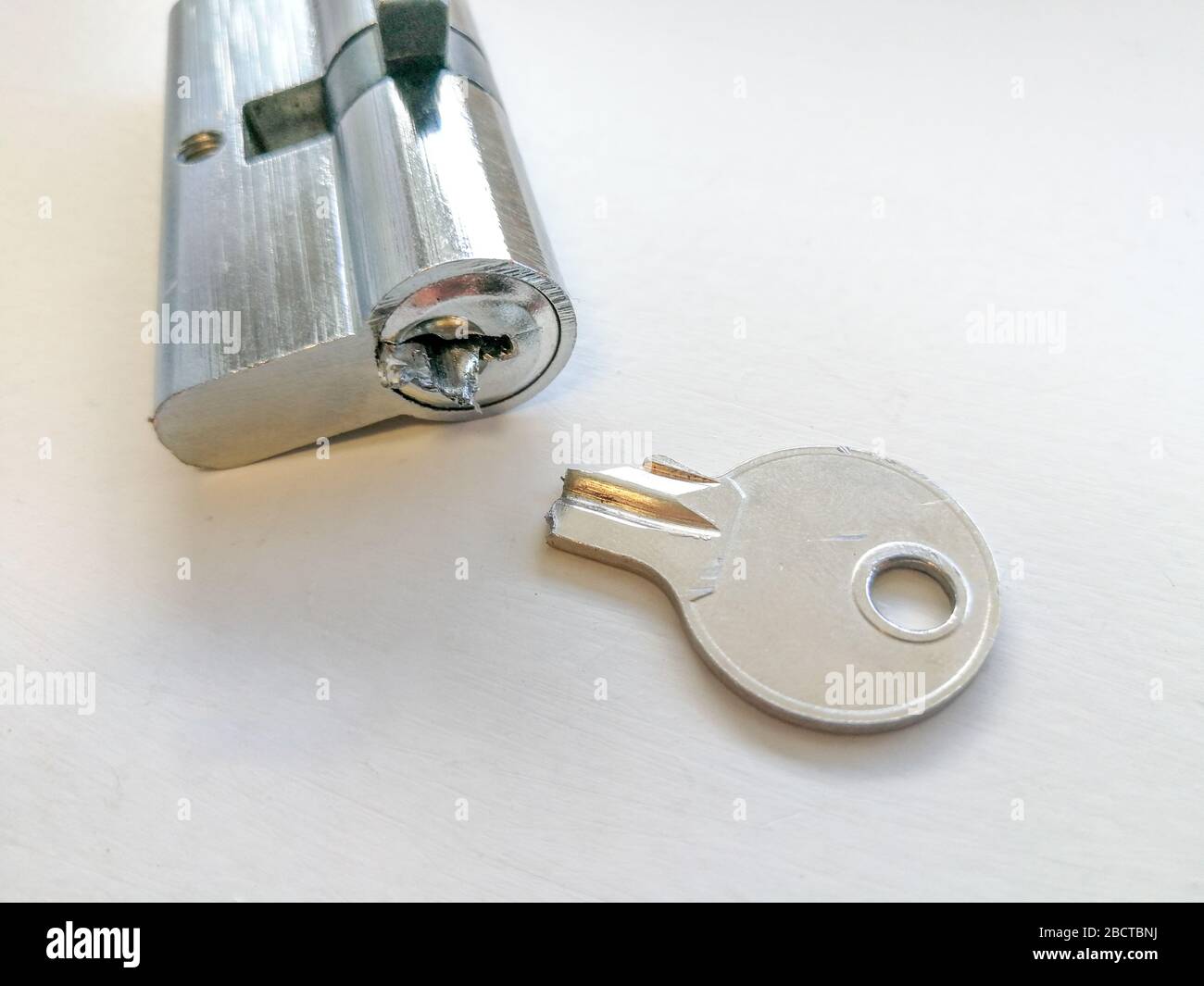 Broken key and lock with half of key inside close up Stock Photo - Alamy