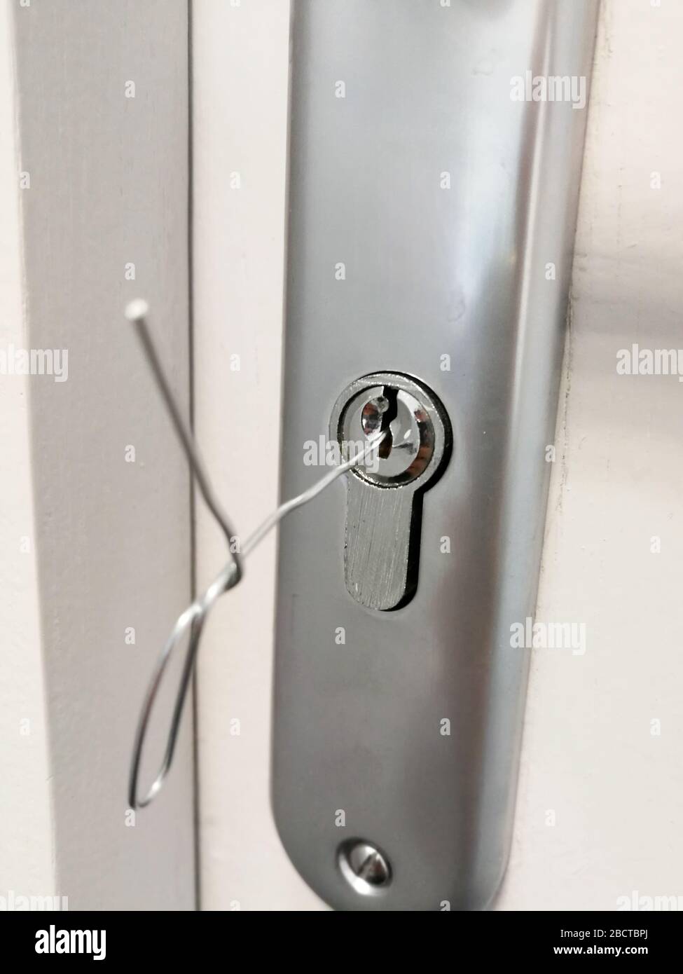 Small metal wire inserted in the keyhole of the door for unlocking ...