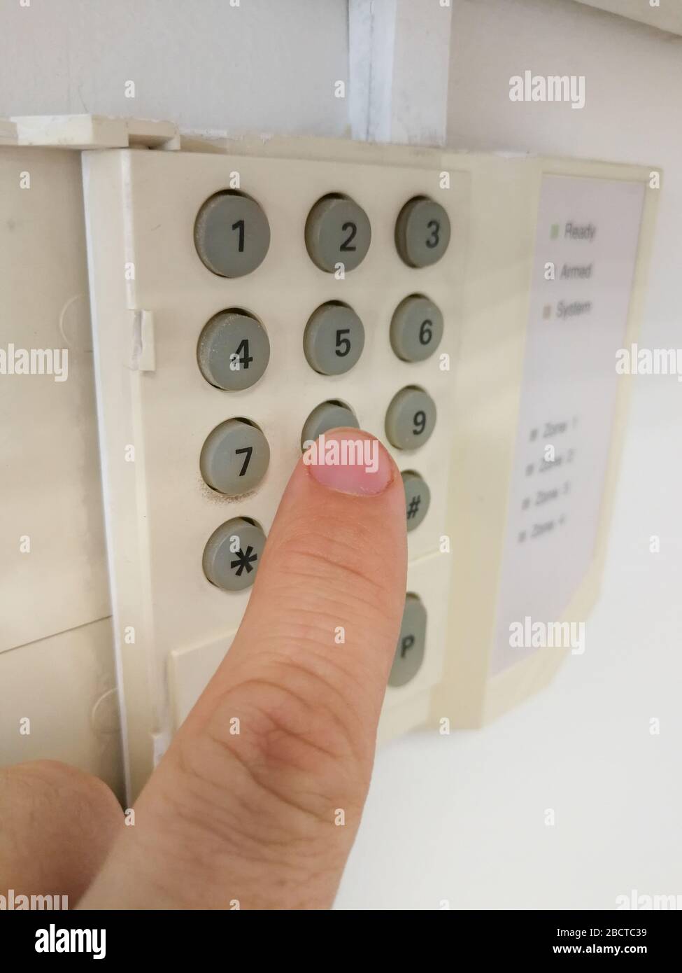 Male finger pressing soft buttons on the alarm control panel for ...