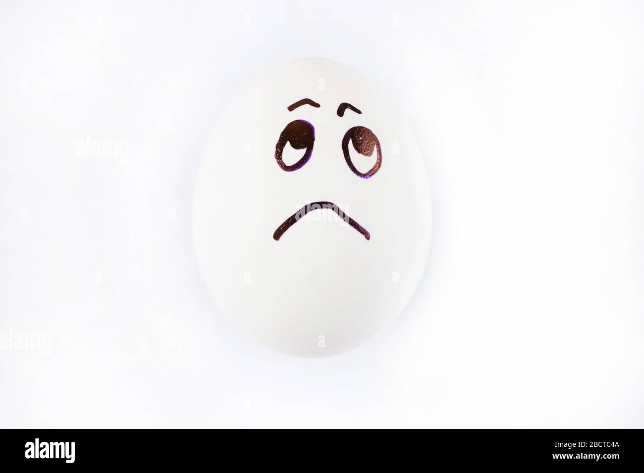 Sad face drawn on white Easter egg Stock Photo - Alamy