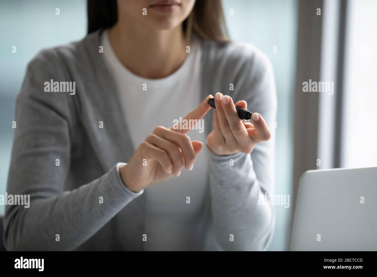 Female diabetic employee test sugar level at workplace Stock Photo - Alamy