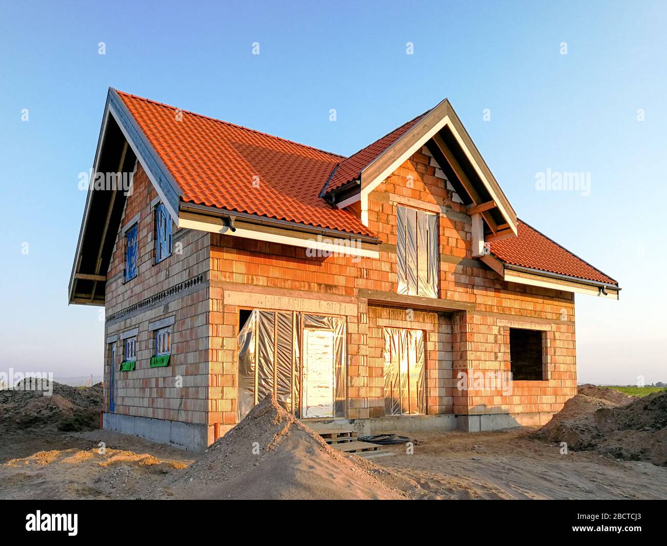 Modern house constructions. Half finished house with roof during ...