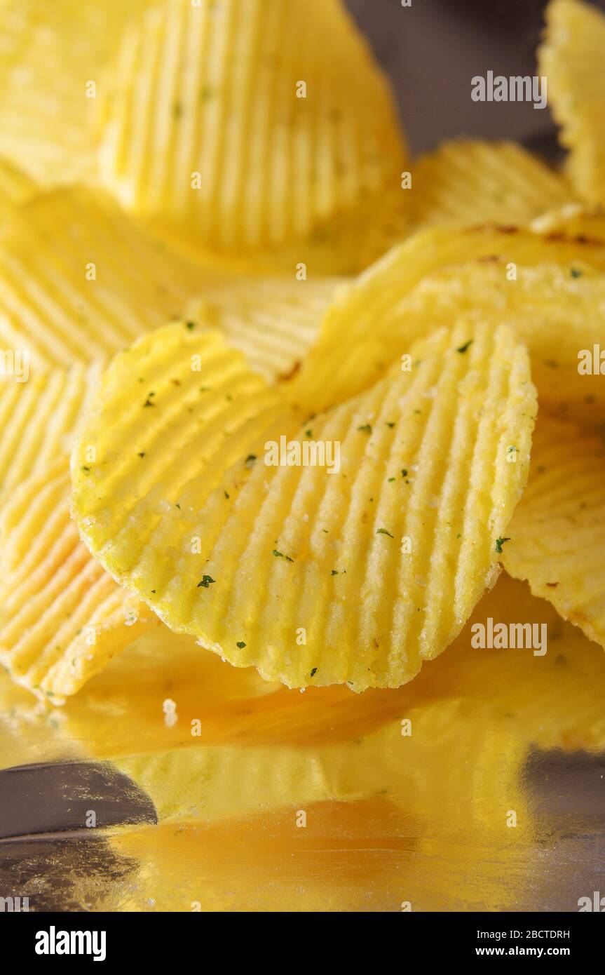 Wavy potato chips isolated on the dark background Stock Photo - Alamy