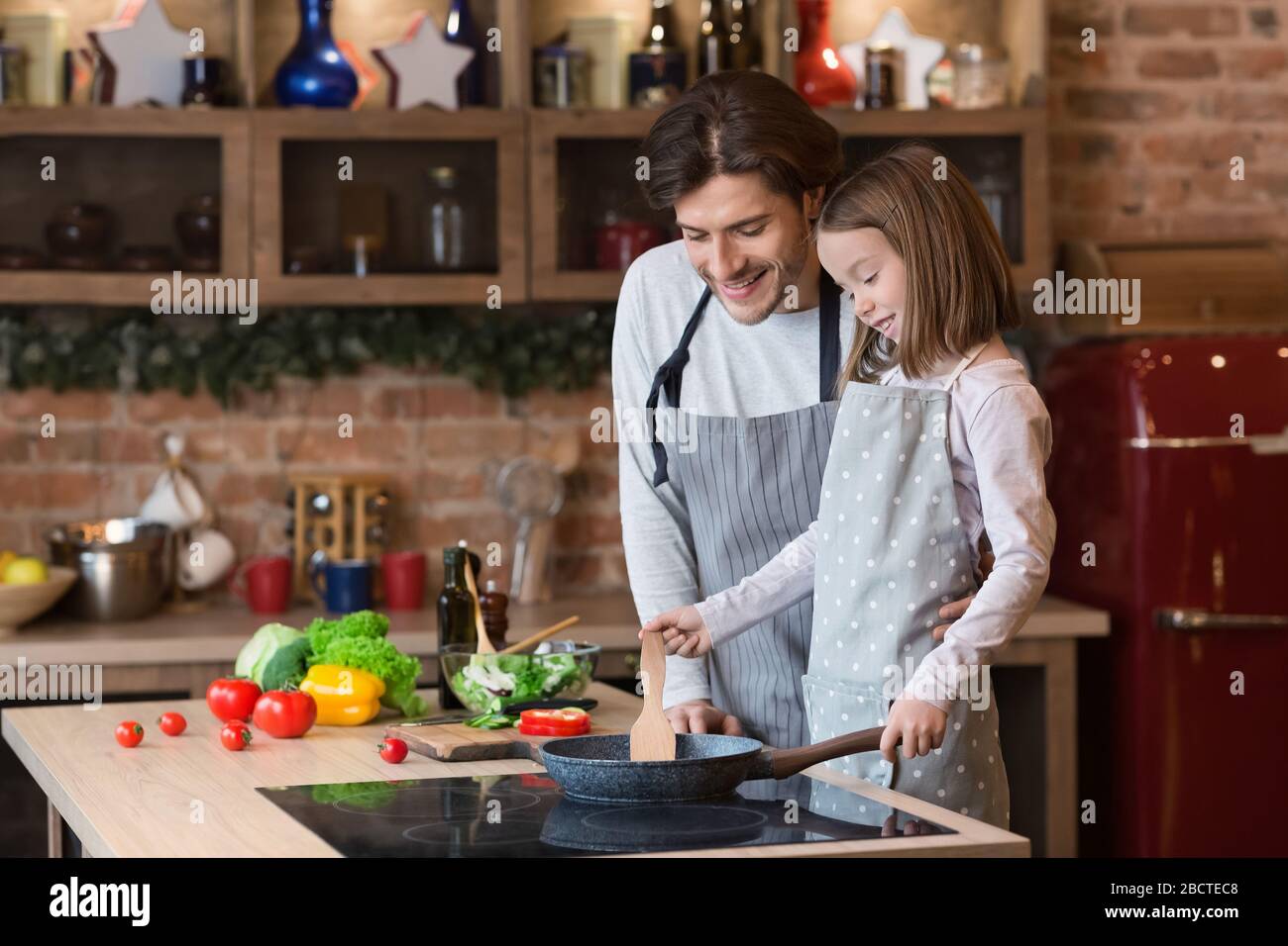 Dad teaching his cute daughter how to cook food on pan Stock Photo - Alamy
