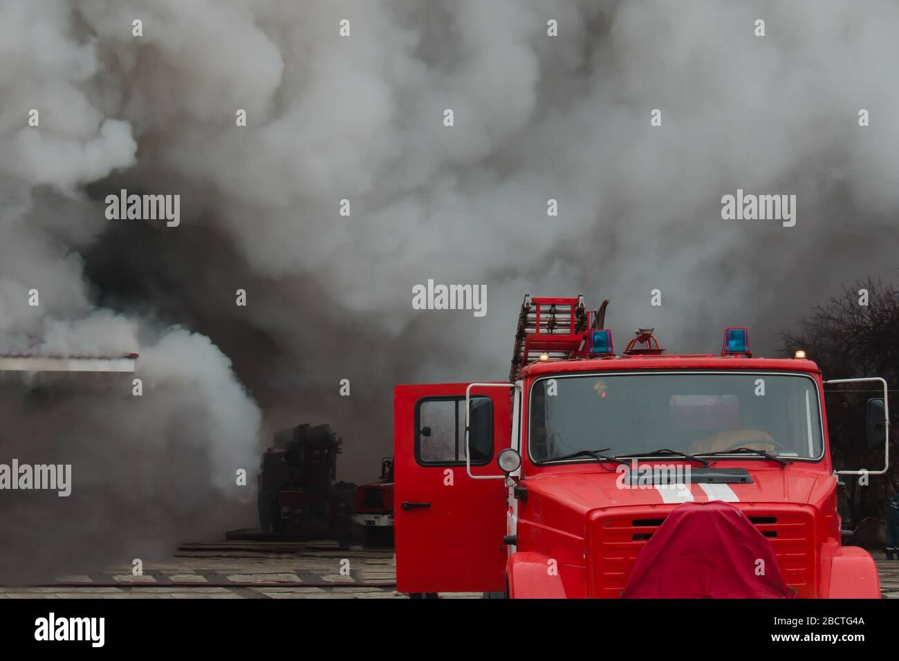 fire fighting and assistance. fire engine in the smoke from the fire ...