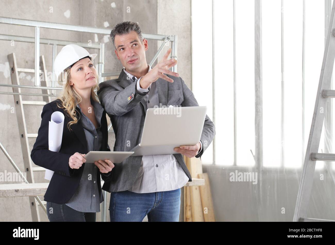 man and woman architects or engineers with computer work together in ...