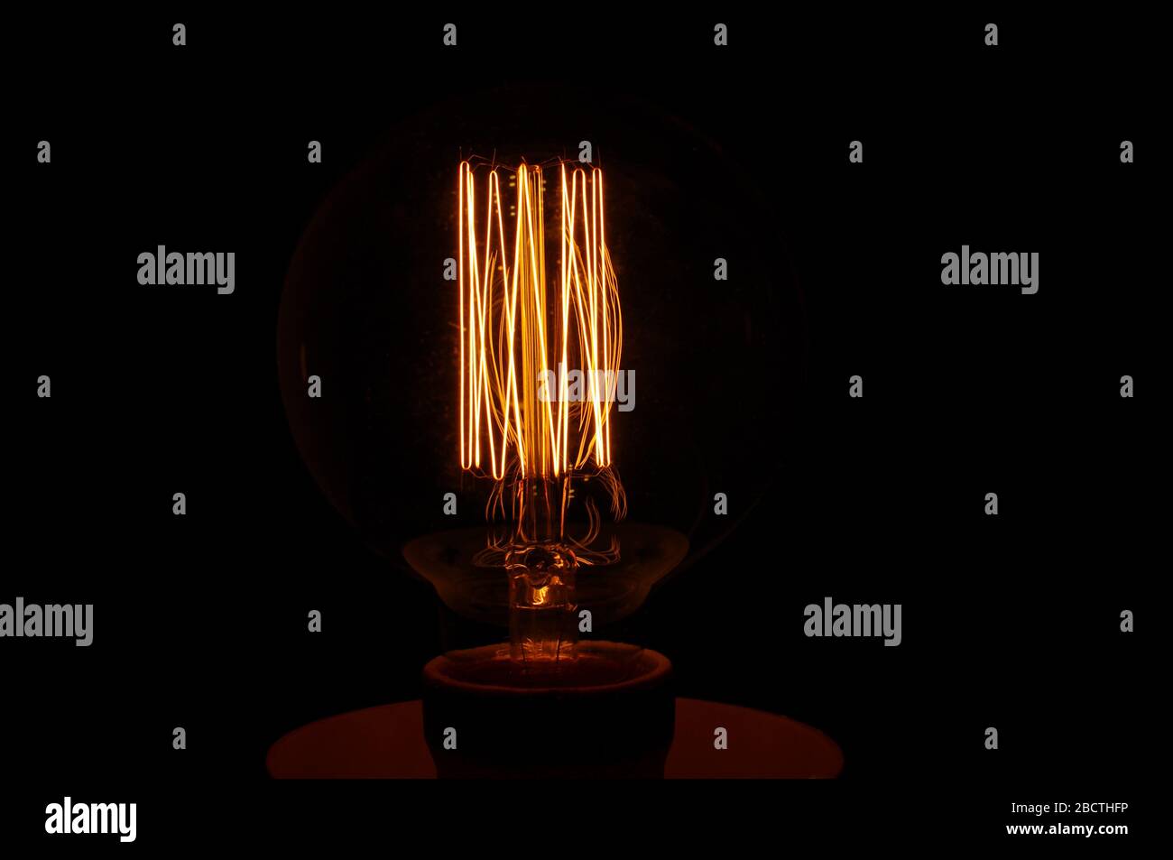 Old style lamp filament glowing in the dark Stock Photo - Alamy