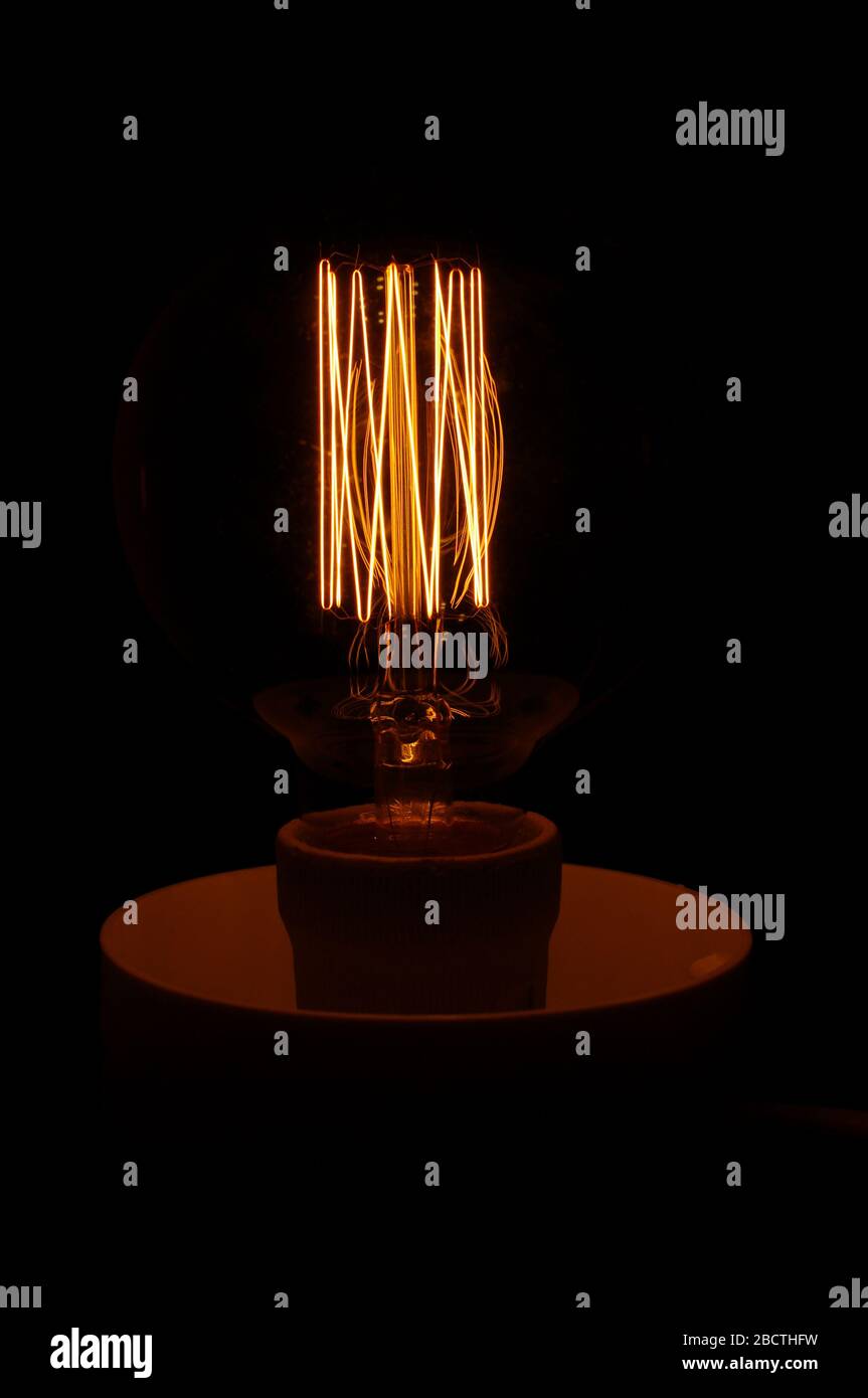 Old style lamp filament glowing in the dark Stock Photo - Alamy