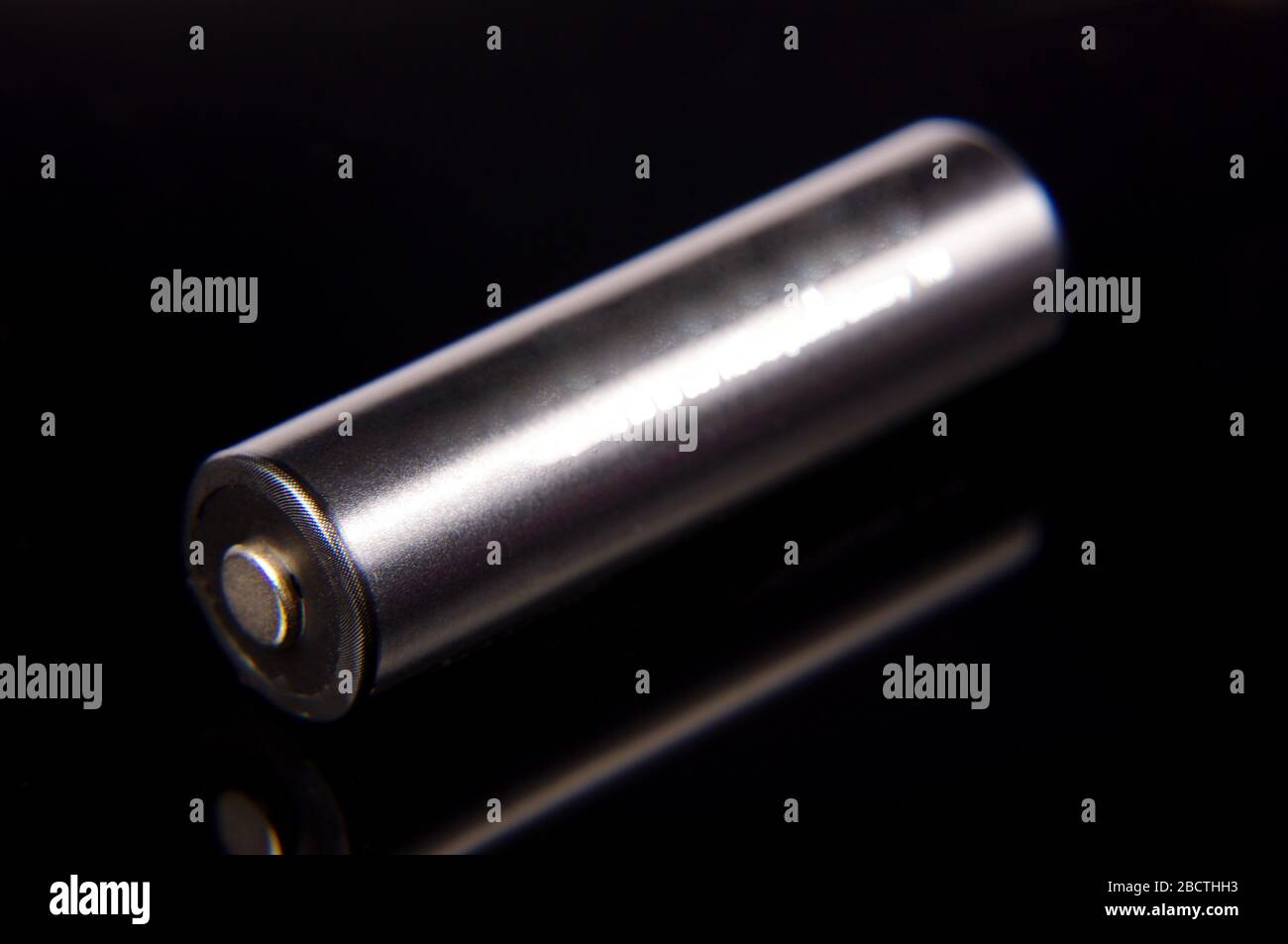Black AA battery on the dark reflective background Stock Photo - Alamy