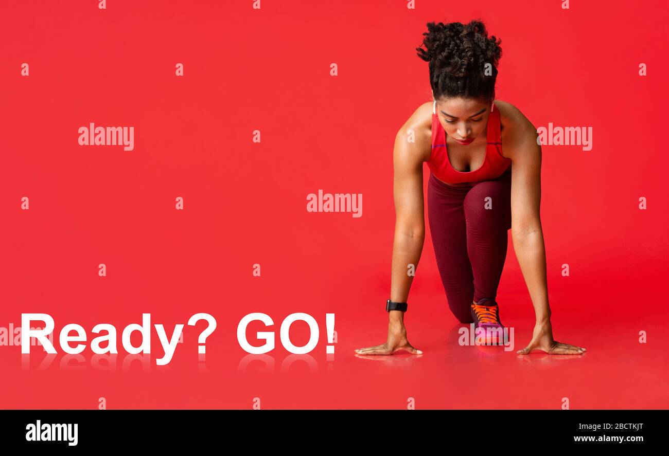 Ready To Start. Sporty black woman on starting position before run ...