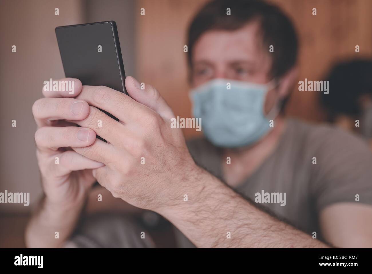Worried man using mobile phone in home quarantine self-isolation for ...