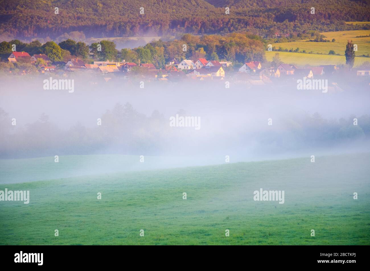 Rural village in calm spring morning covered in mist Stock Photo - Alamy