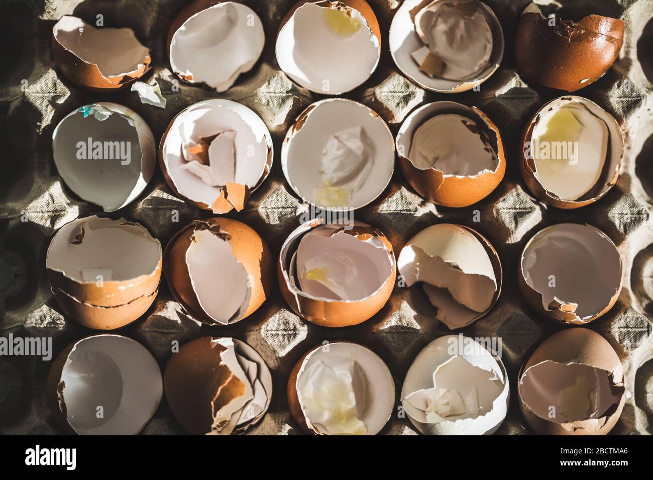 Texture of broken empty eggshell in carton box. View from above ...
