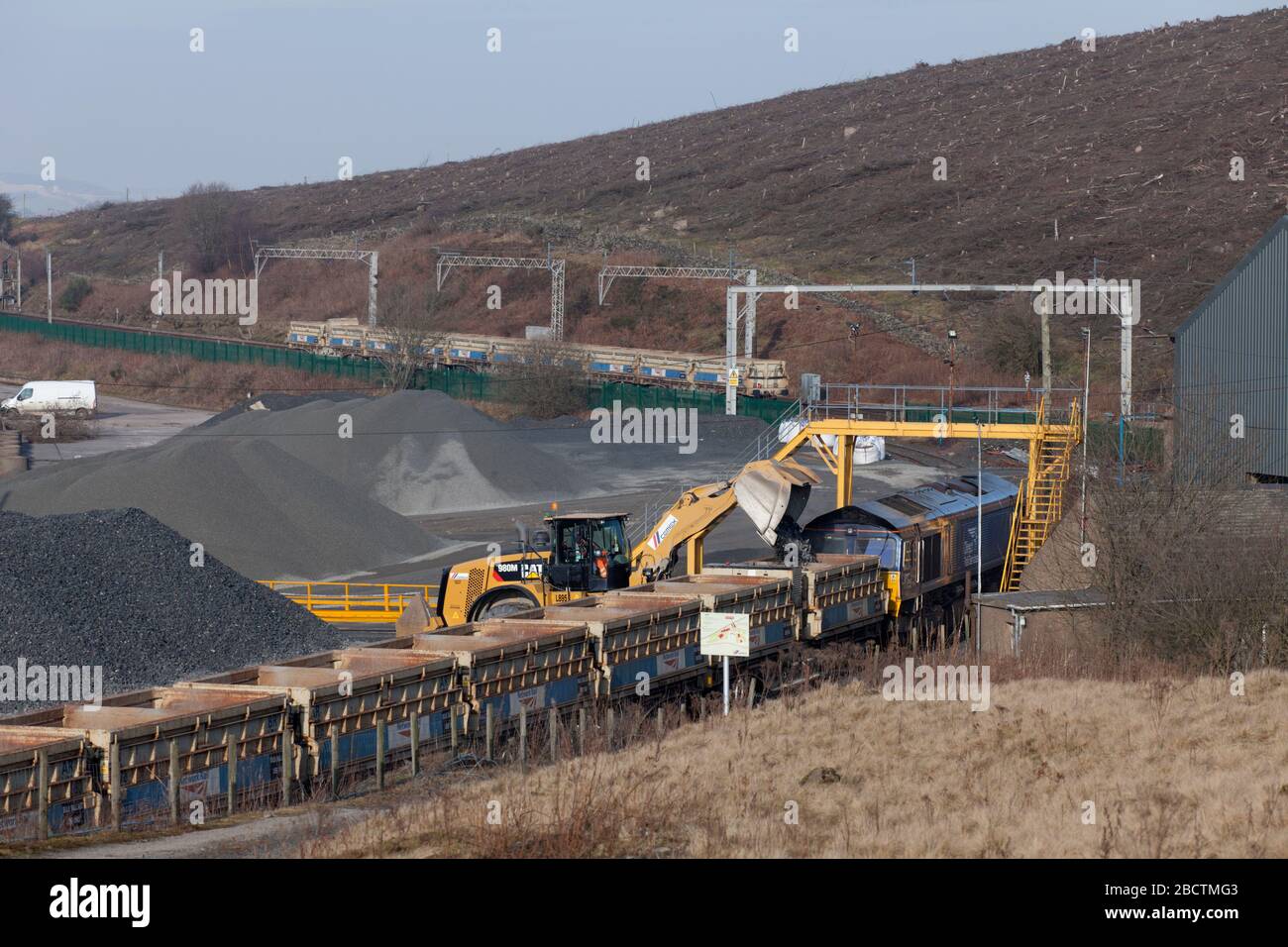 Cat loading shovel loading a freight train with railway ballast at the ...