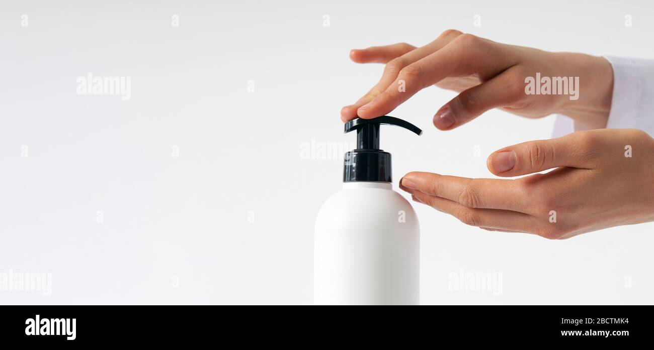 Woman hands pushing pump plastic soap bottle with copy space, using ...