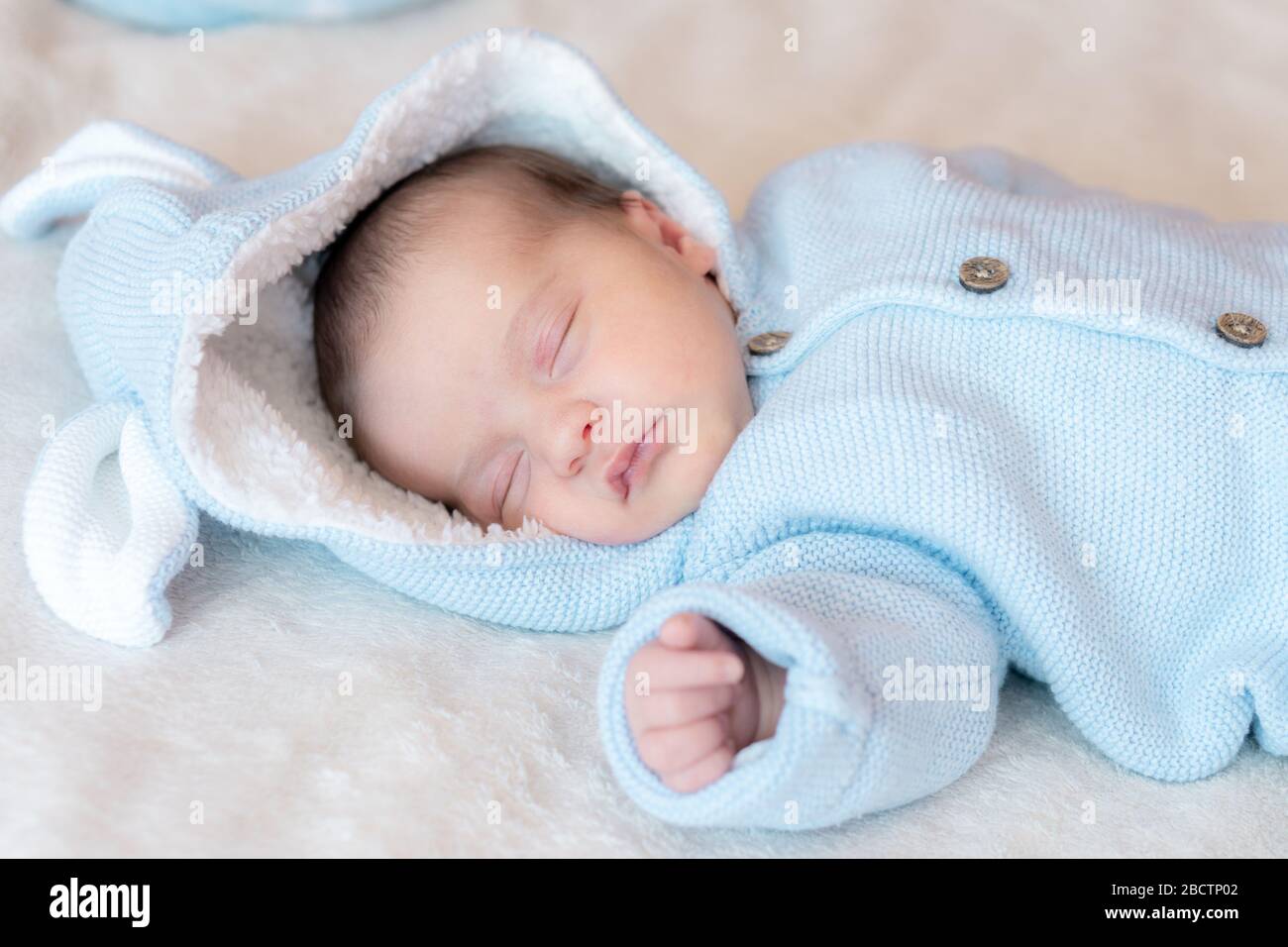 Newborn baby close-up. Side view of a newborn baby sleeping soundly on ...