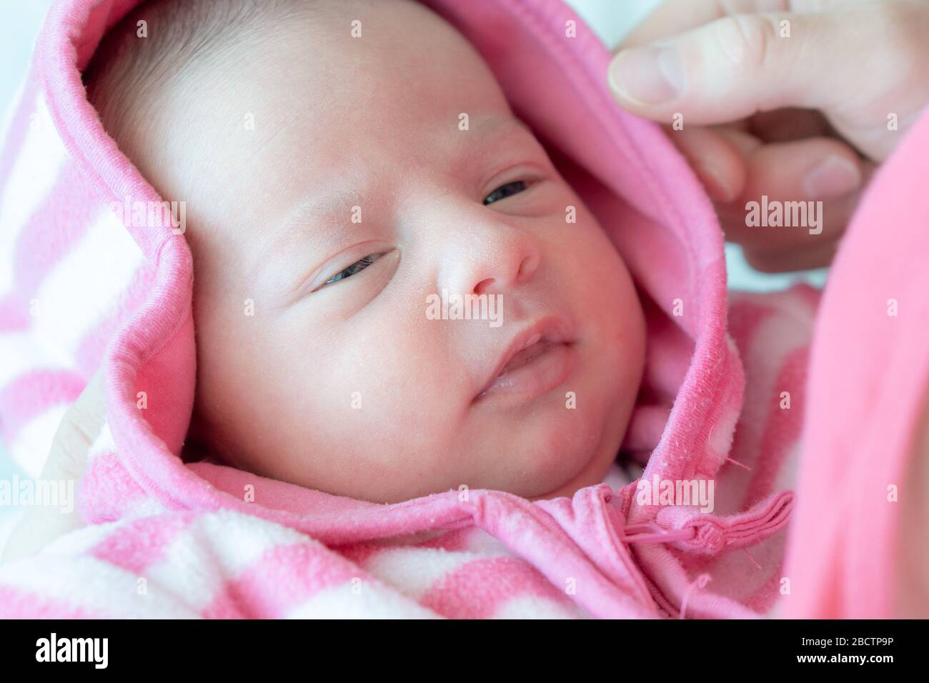 Newborn in the arms of mom. Portrait of a newborn baby. Close-up face ...