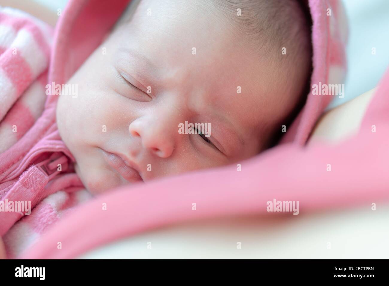 Newborn in the arms of mom. Portrait of a newborn baby. Close-up face ...