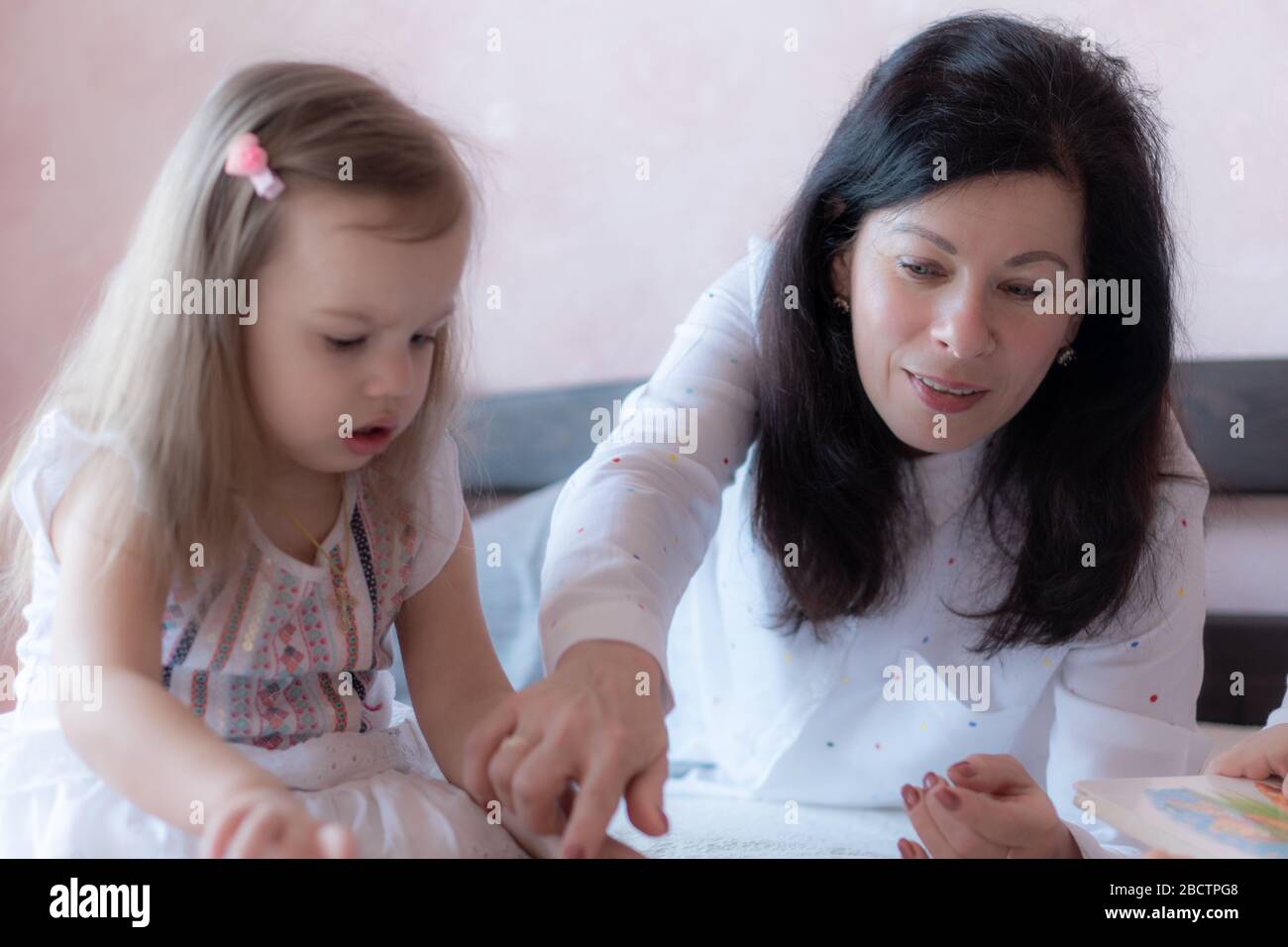 Grandmother with grandson and granddaughter in bed reading a book ...