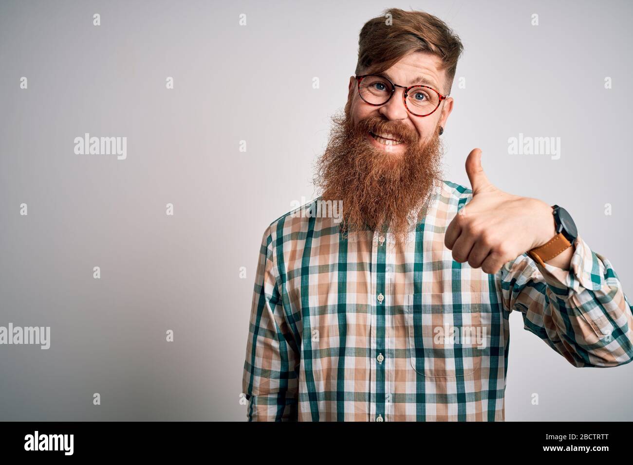 Handsome Irish redhead man with beard wearing glasses and hipster shirt ...