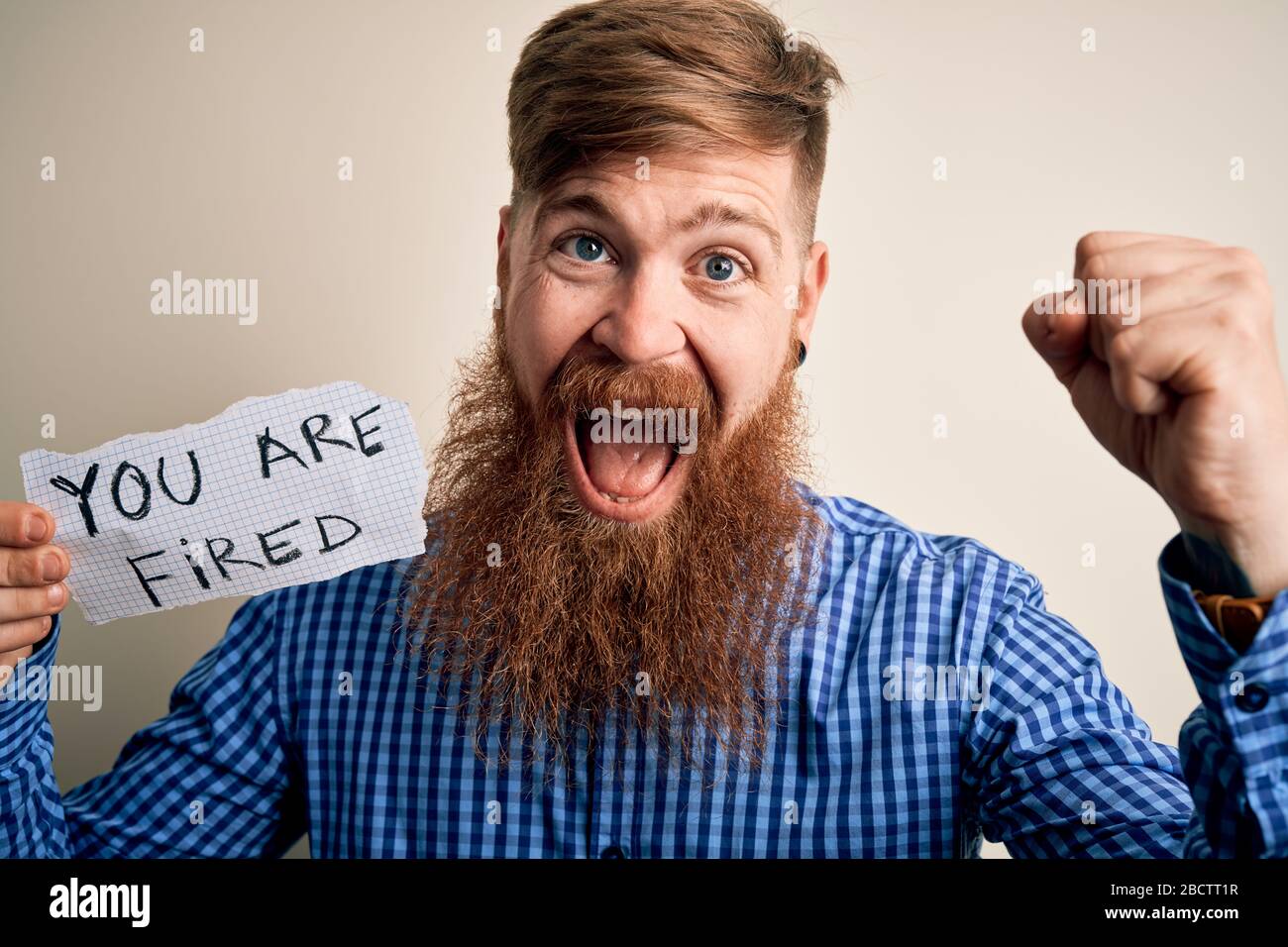 Redhead Irish business man with beard holding paper with you are fired ...