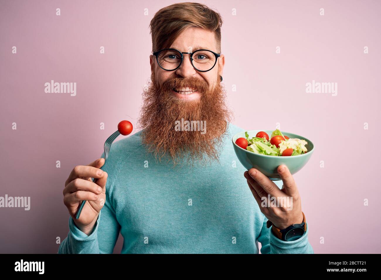 Redhead Irish healthy man with beard eating vegetarian green salad over ...