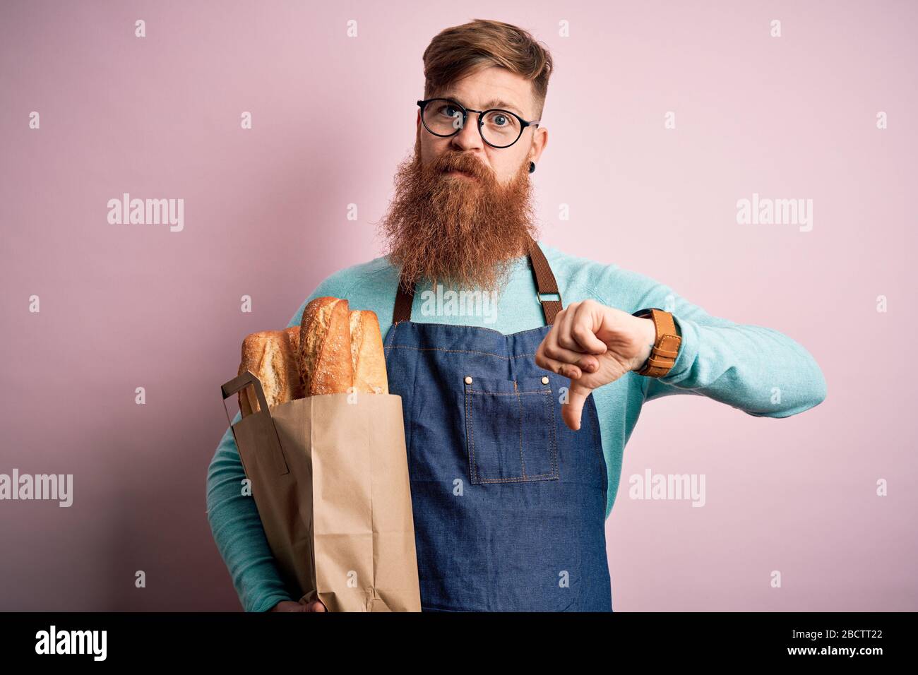 Irish redhead baker man with beard holding groceries paper bag of bread ...