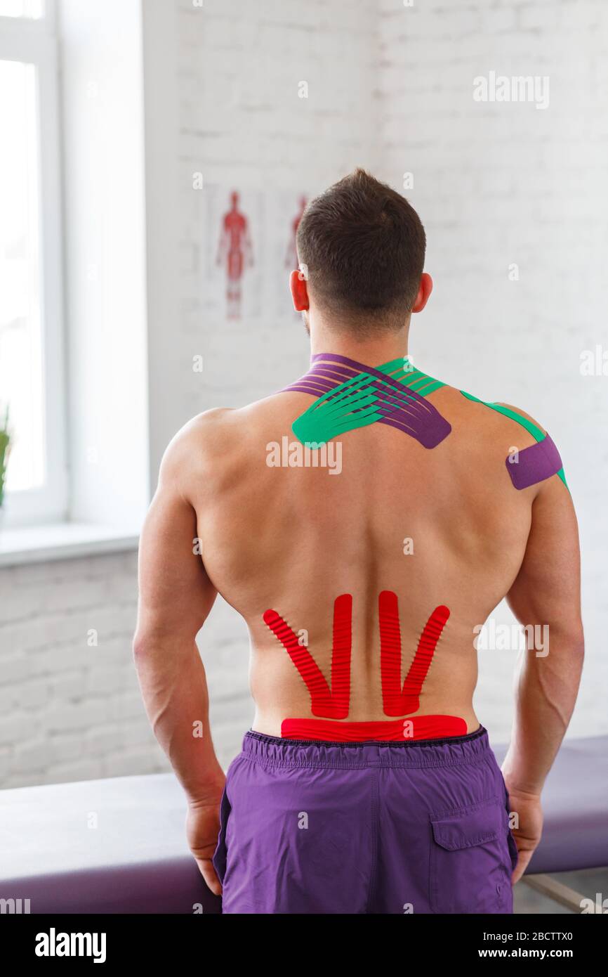 Kinesiology taping. Physical therapist applying kinesiology tape to ...