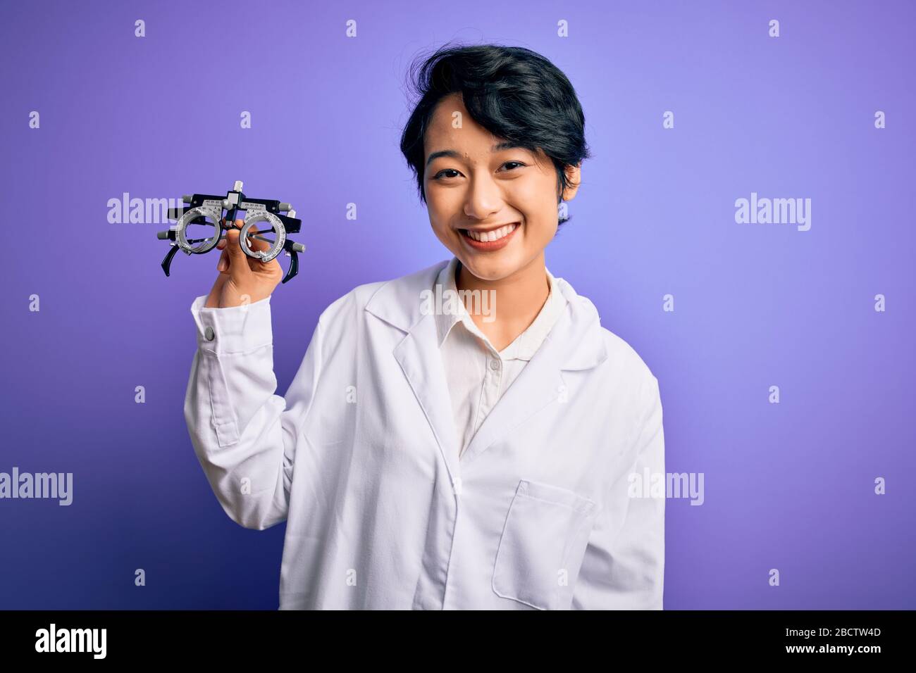 Beautiful asian optical girl wearing coat holding optometry glasses ...