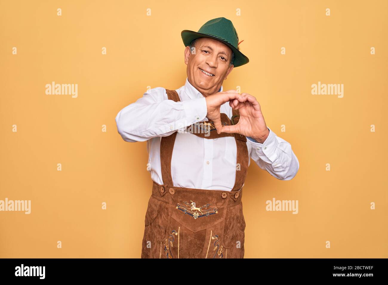 Senior grey-haired man wearing german traditional octoberfest suit over ...