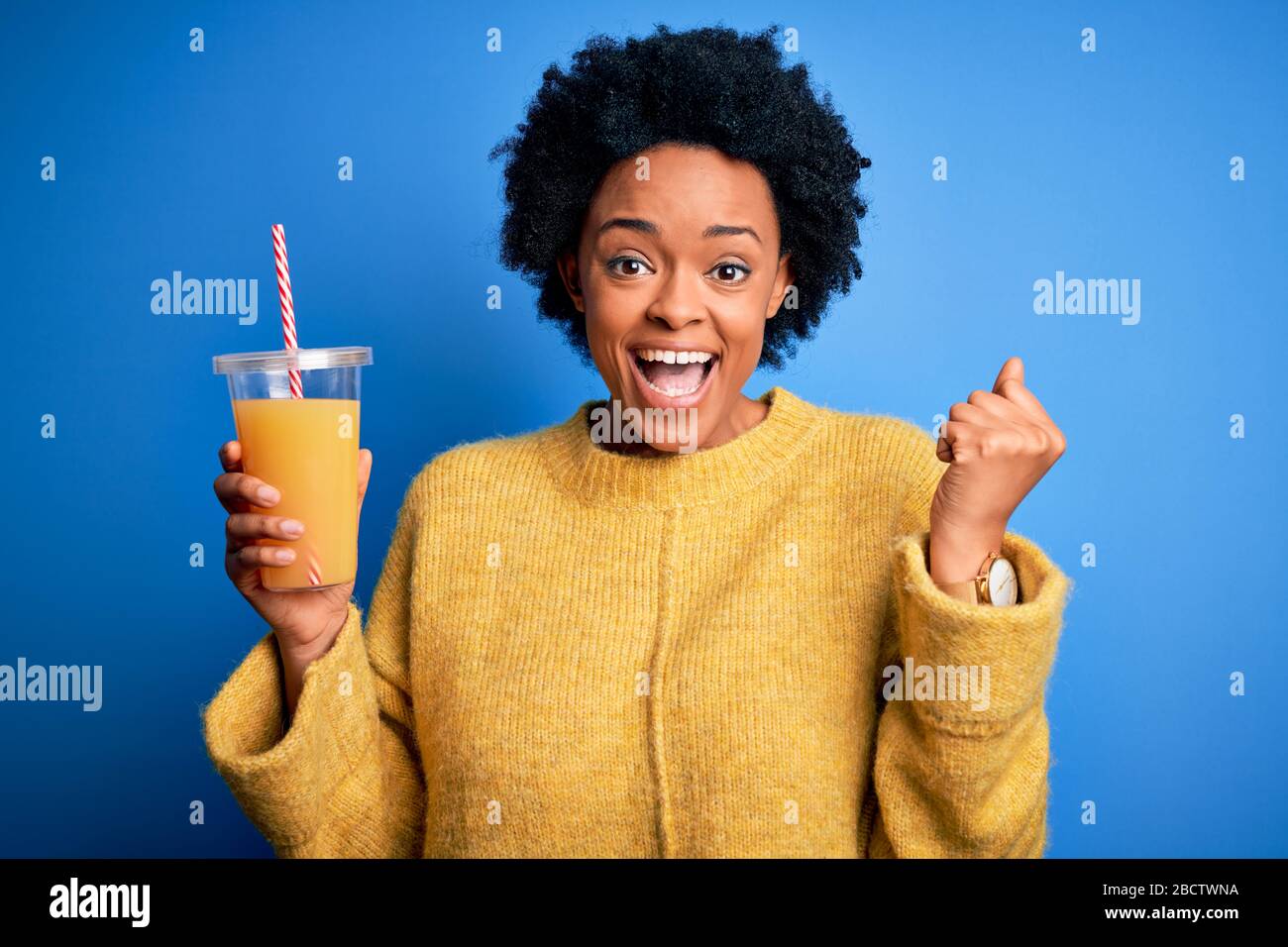 Young African American afro woman with curly hair drinking healthy ...