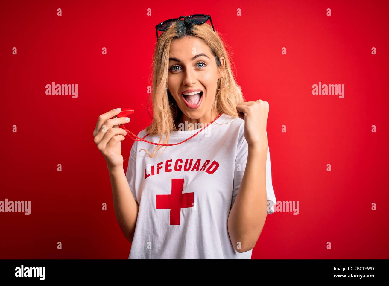 Young beautiful blonde lifeguard woman wearing t-shirt with red cross ...