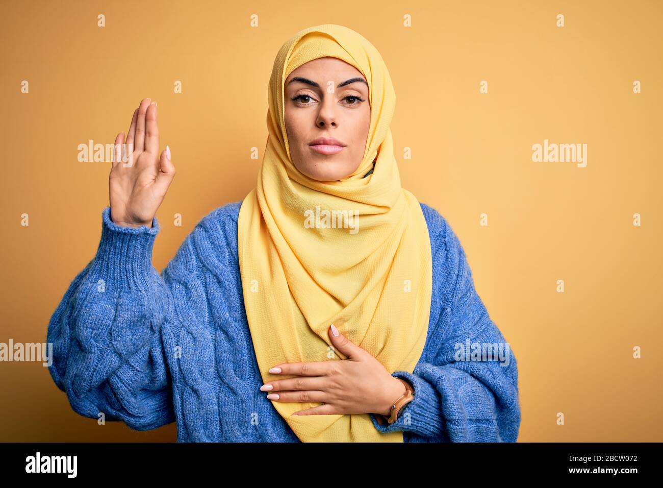 Young beautiful brunette muslim woman wearing arab hijab over isolated ...