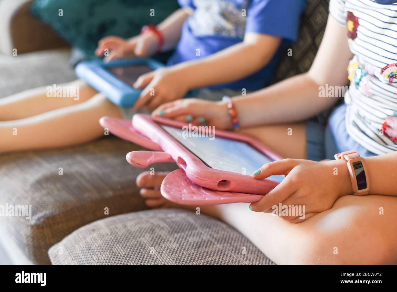 Children using their tablet device to play computer games and use ...