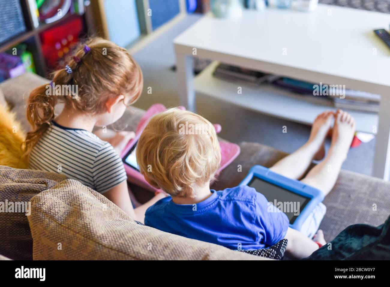 Children using their tablet device to play computer games and use ...