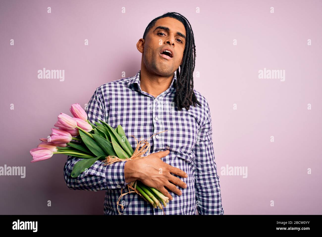 Young african american afro romantic man with dreadlocks holding ...