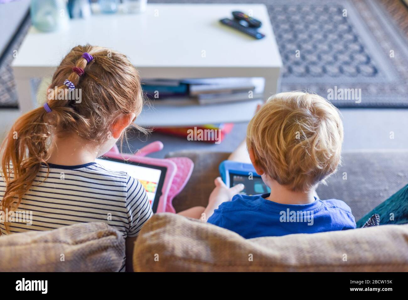 Children using their tablet device to play computer games and use ...