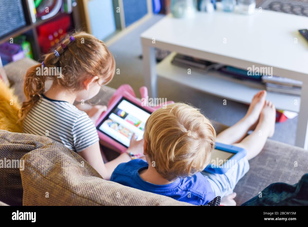 Children using their tablet device to play computer games and use ...
