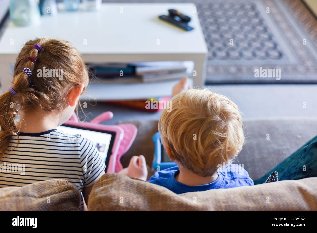 Children using their tablet device to play computer games and use ...