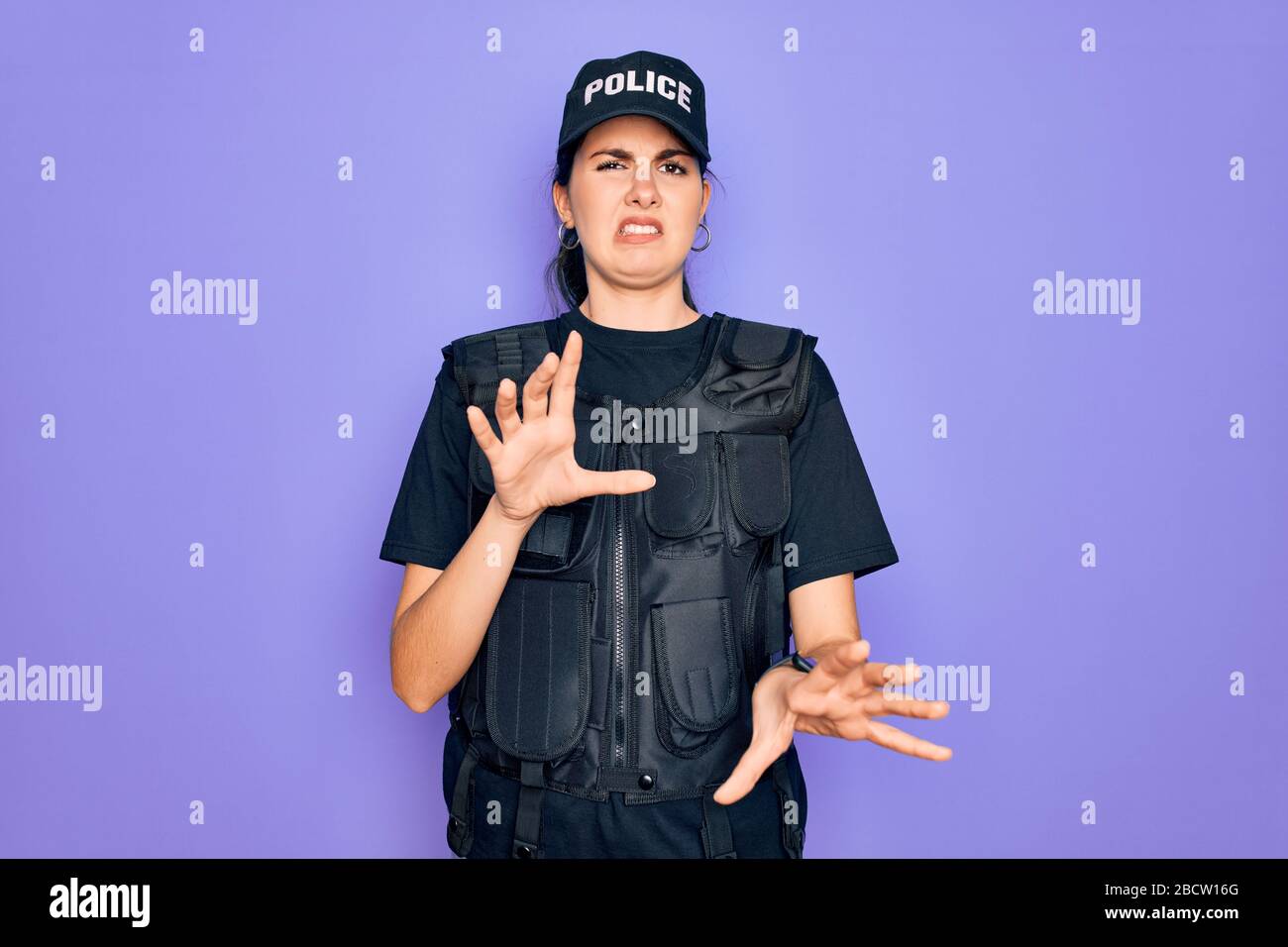 Young police woman wearing security bulletproof vest uniform over ...