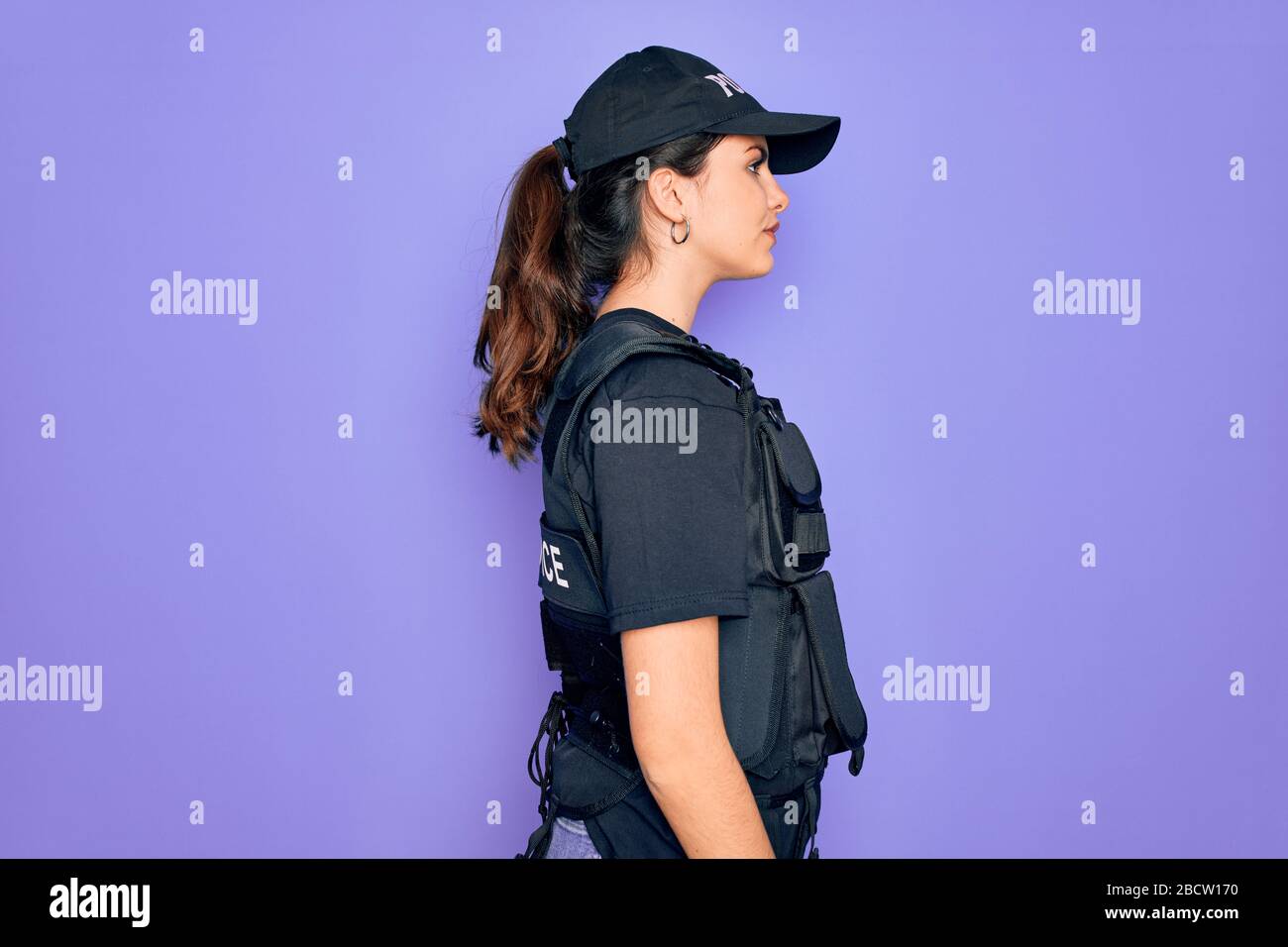Young police woman wearing security bulletproof vest uniform over ...