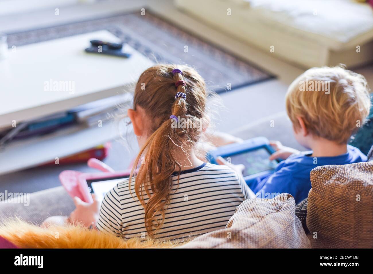 Children using their tablet device to play computer games and use ...