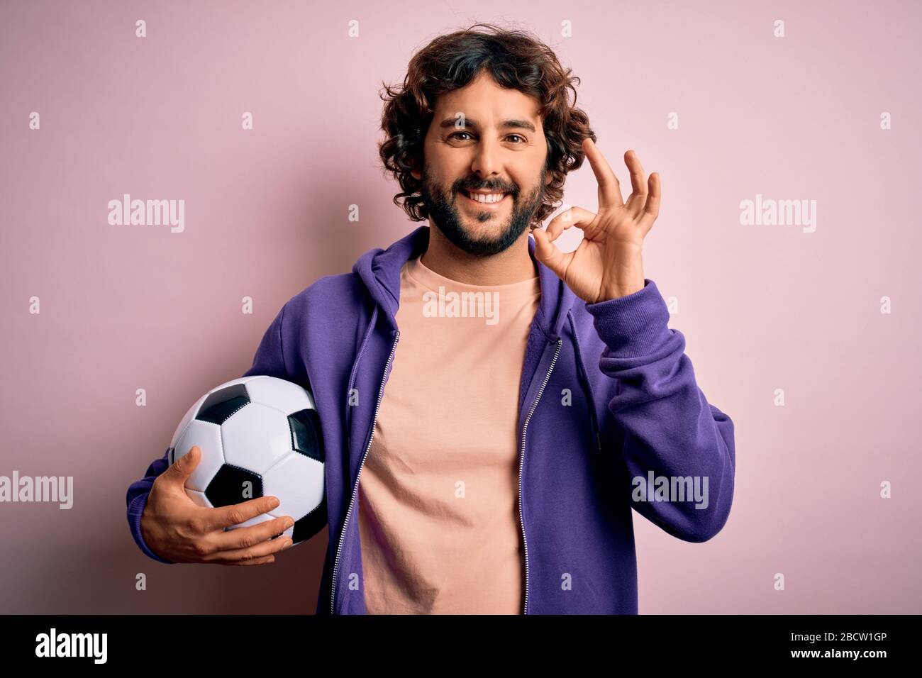 Handsome player man with beard playing soccer holding football ball ...