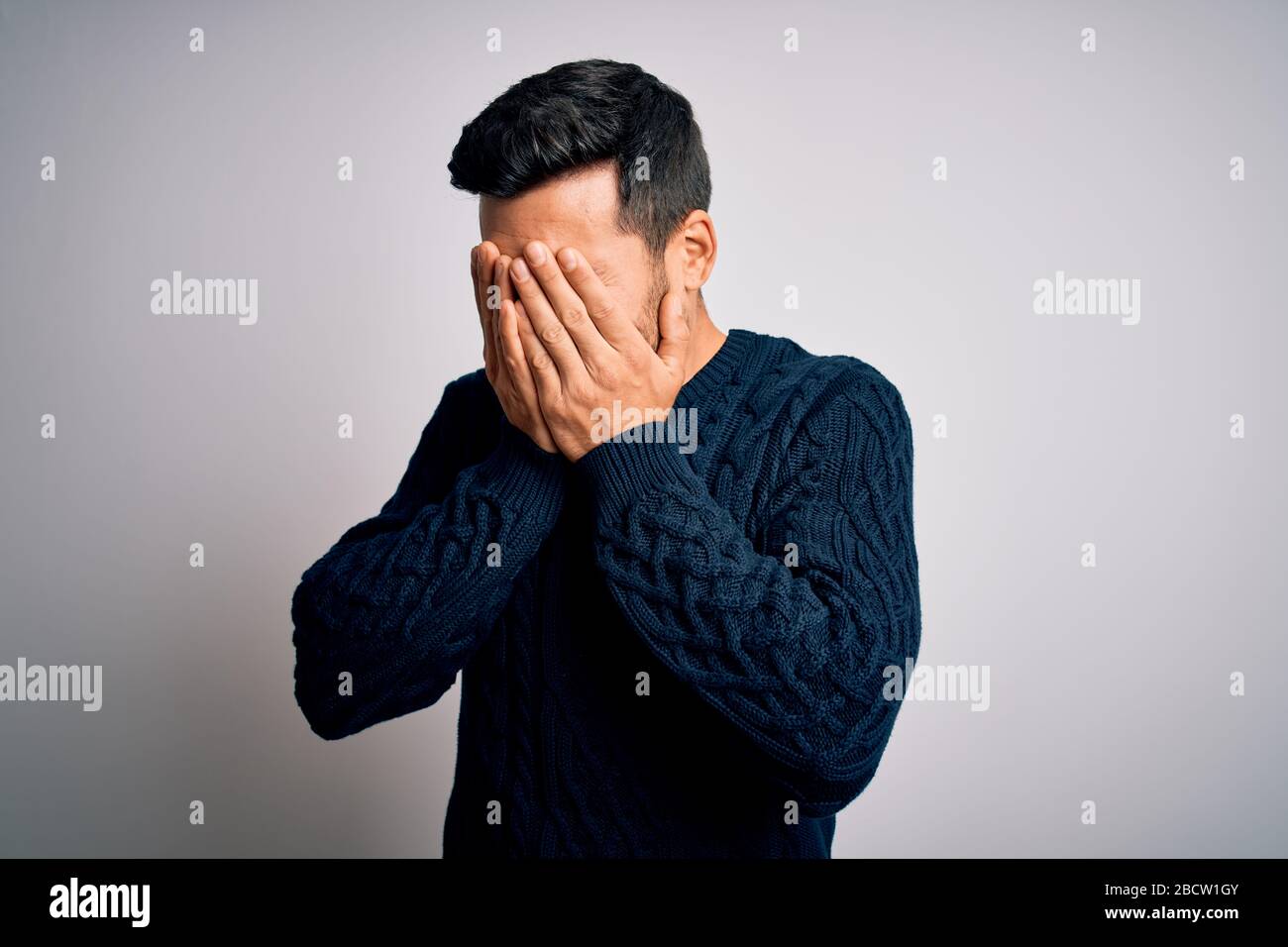 Young handsome man with beard wearing casual sweater standing over ...
