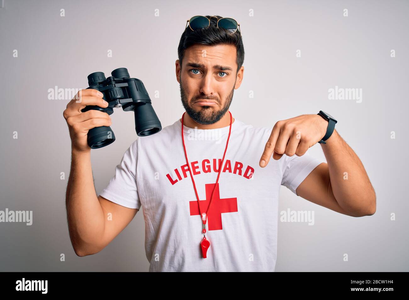 Young lifeguard man with beard wearing t-shirt with red cross and ...