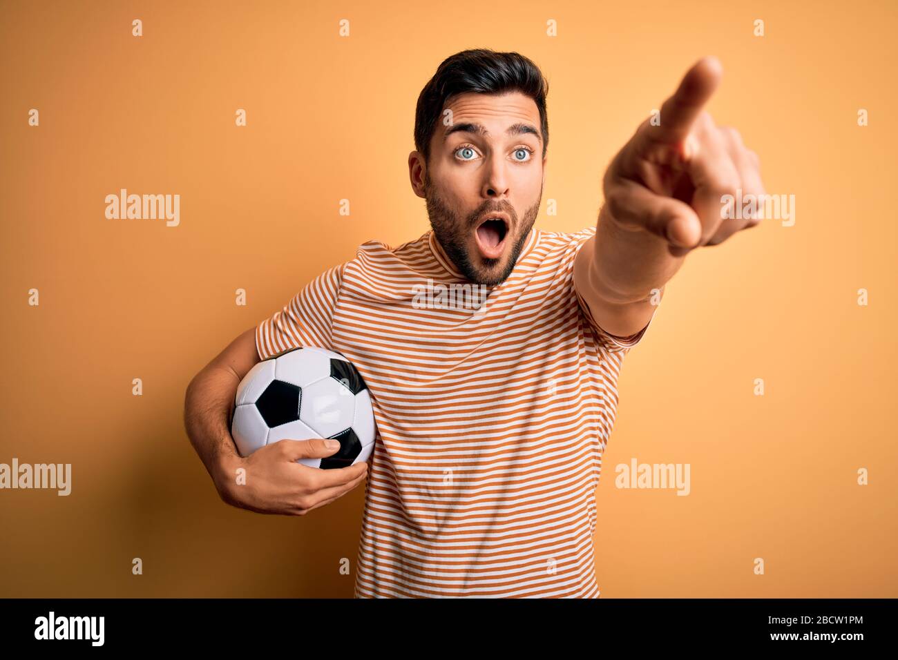 Handsome player man with beard playing soccer holding footballl ball ...